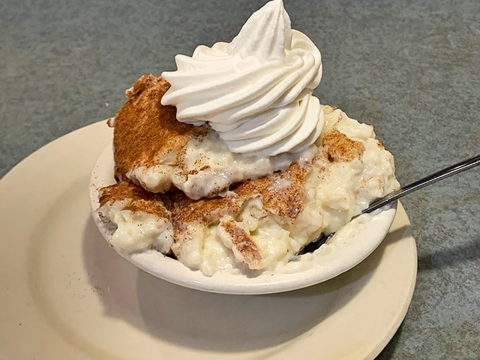 Rice pudding that would make your grandmother jealous, crowned with a cloud of whipped cream and a sprinkle of cinnamon that whispers, "Take a nap after this."