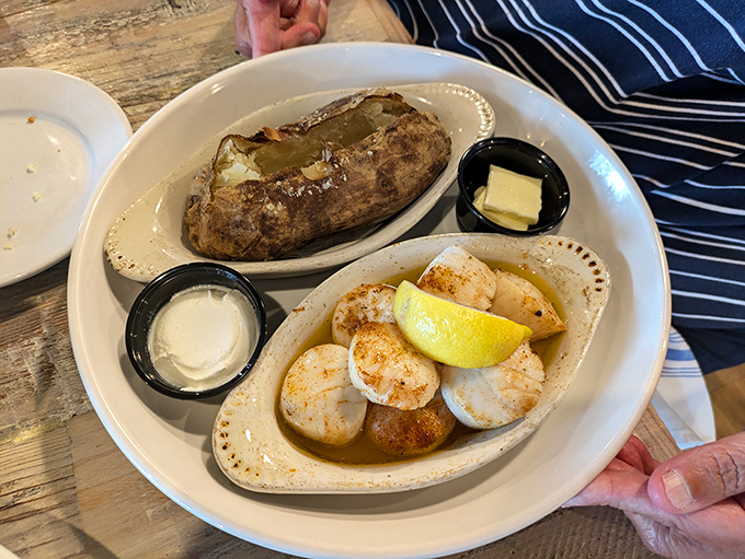 Perfectly seared scallops alongside a fluffy baked potato&mdash;proof that sometimes the simplest combinations create the most memorable meals.