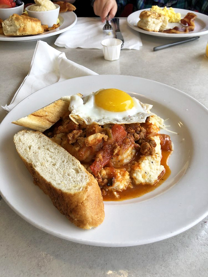 This breakfast sandwich isn't just served, it's presented&mdash;a sunny egg atop layers of savory goodness with a biscuit standing guard.