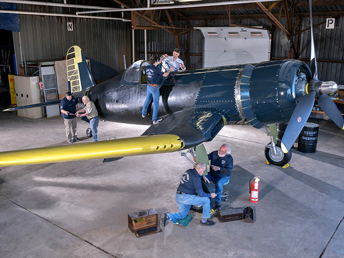 Restoration in action! Volunteers work with surgical precision on a vintage aircraft, proving that sometimes the best museum exhibits are the ones still coming together.