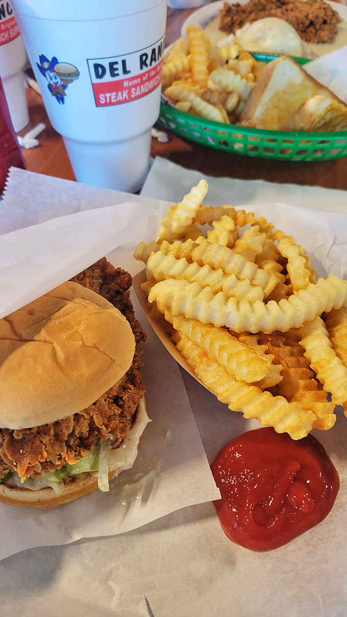 The legendary Steak Sandwich Supreme in its natural habitat, alongside golden crinkle-cut fries. Notice how the meat rebelliously refuses to be contained by mere bread.