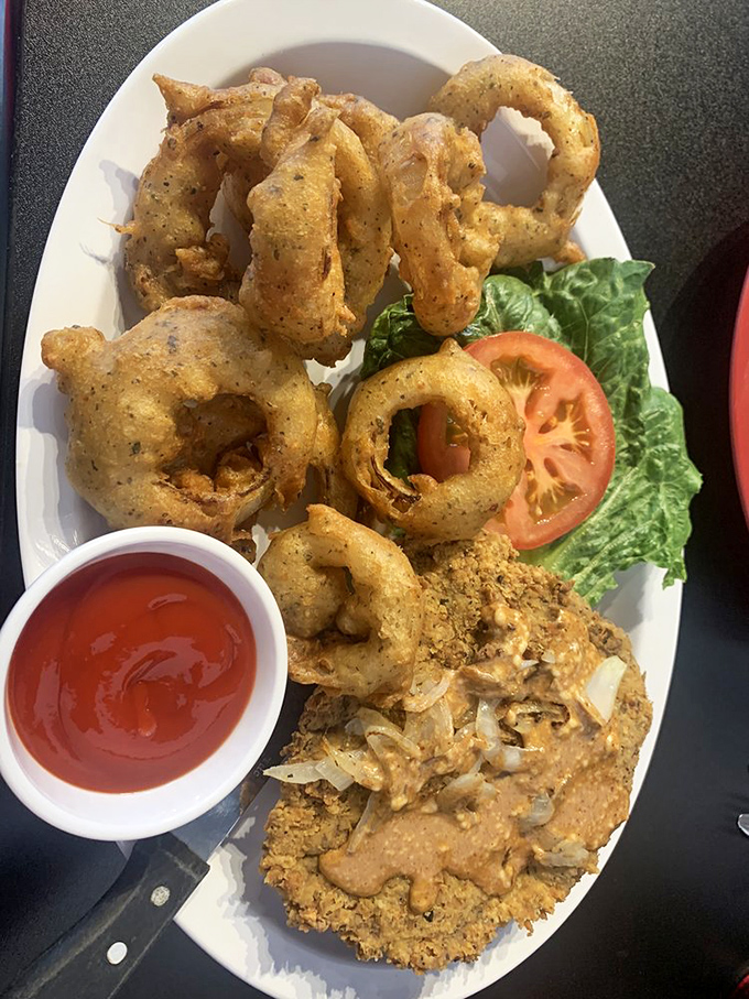 These onion rings aren't just fried – they're golden halos of happiness, perfectly paired with what appears to be chicken fried steak heaven.