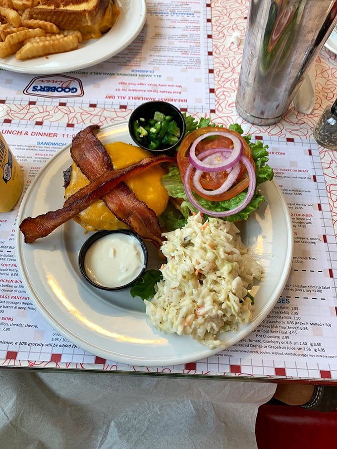 This isn't just a burger&mdash;it's architecture on a plate. Crispy bacon standing guard over melted cheese, with coleslaw providing a cooling counterpoint to all that savory glory.