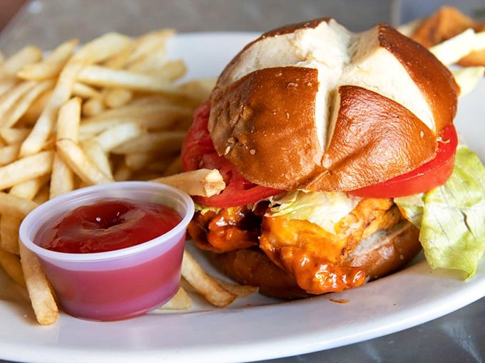 This isn't just a sandwich; it's architecture with attitude. The pretzel bun cradles hot chicken like it was born for this purpose.