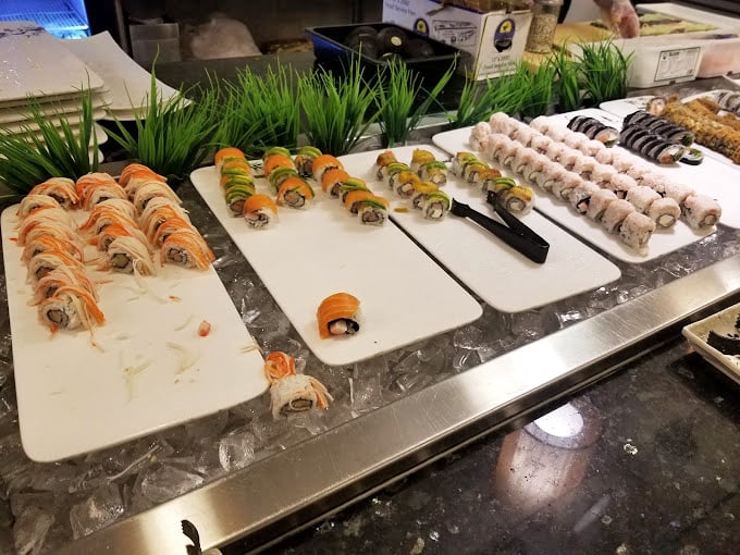 Sushi rolls lined up like colorful soldiers, ready to march straight into your heart. That avocado-topped creation is calling your name.