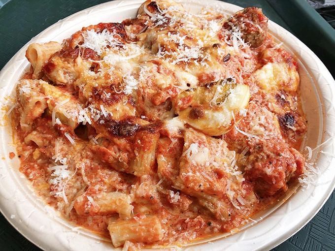 Mezzemaniche pasta embracing its sauce like long-lost lovers. This isn't just dinner—it's a relationship on a plate.