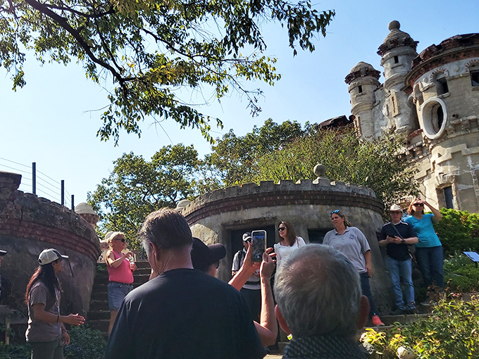 Tour guides share the island's colorful history with visitors, turning crumbling walls into vivid stories of explosions, fires, and eccentric vision.