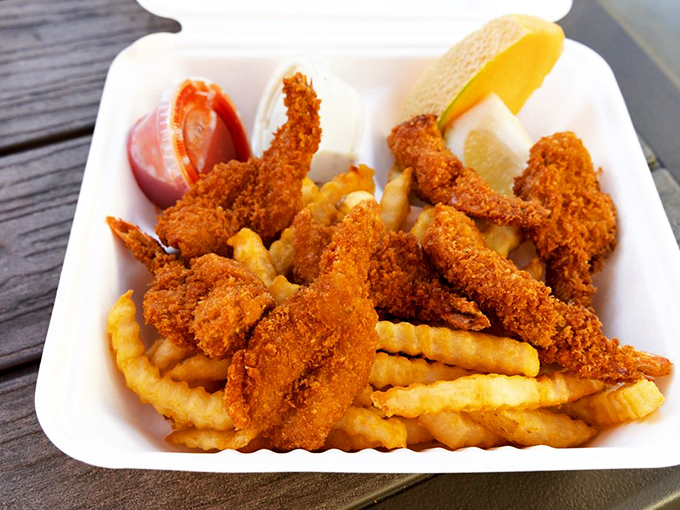 Golden-battered prawns perched atop a mountain of crispy fries—proof that sometimes the simplest pleasures are the most satisfying.