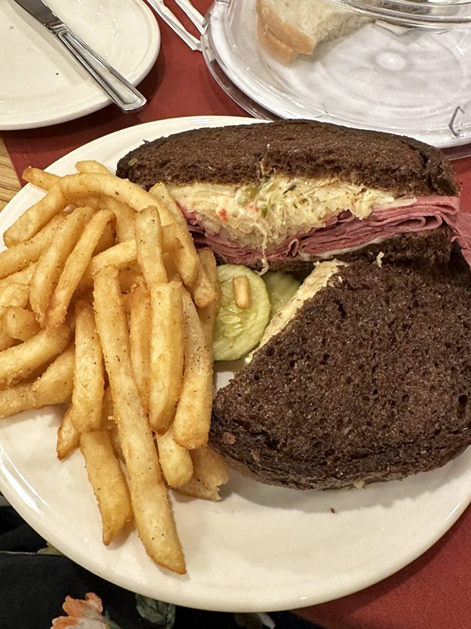 A Reuben sandwich so authentic it might ask to see your passport, flanked by fries that refuse to play second fiddle.