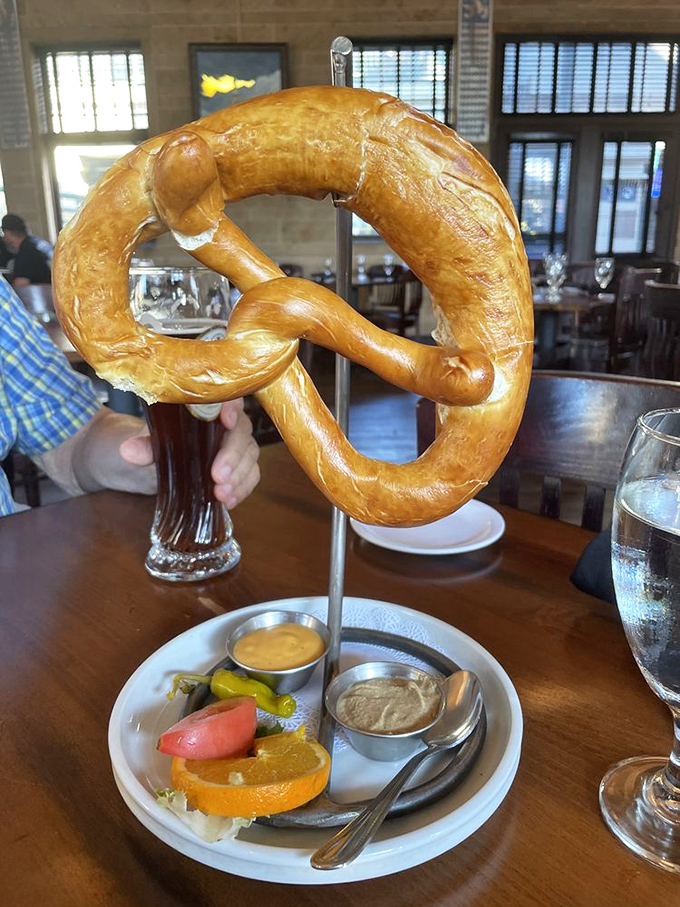 This pretzel arrives like royalty on a throne of condiments, making you question why you've wasted years eating those sad mall versions.