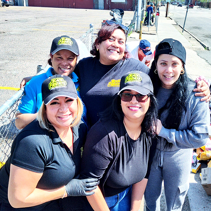 The staff wearing Black Fridays caps share a camaraderie born from helping bargain hunters strike gold. Their smiles say it all: savings make everyone happy.