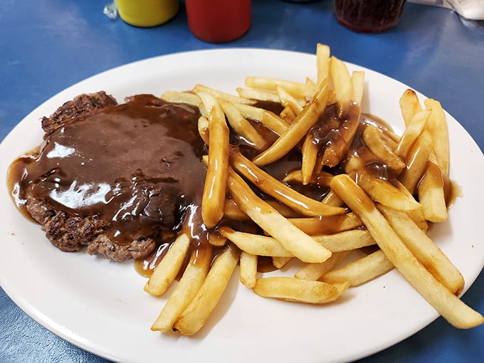 Comfort food geometry: a perfect rectangle of meat, a golden pyramid of fries, all unified by the warm brown river of gravy.