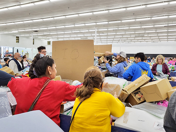 The thrill of the hunt! Shoppers lean in with the focus of diamond cutters, knowing the perfect find might be hiding just beneath that cardboard box.