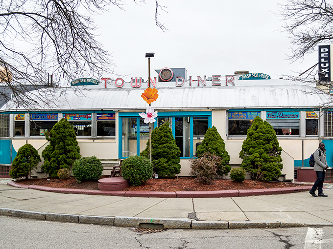 The Deluxe Town Diner's classic silhouette stands proud against cloudy skies, promising warmth both on your plate and in your soul.