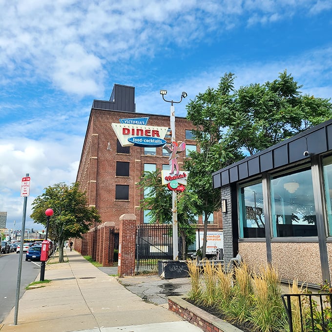 Victoria's Diner stands proud against Boston's brick backdrop, its vintage sign a reminder that some traditions are worth preserving.