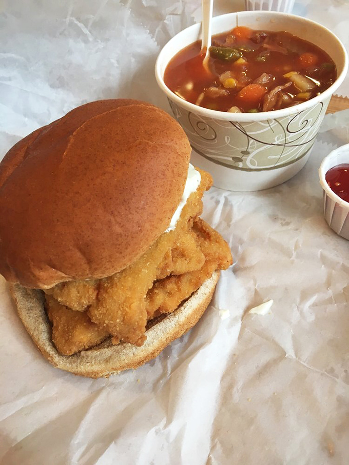 The holy trinity of lunch perfection: a fish sandwich on a bun, hearty vegetable soup, and the anticipation of that first magnificent bite.