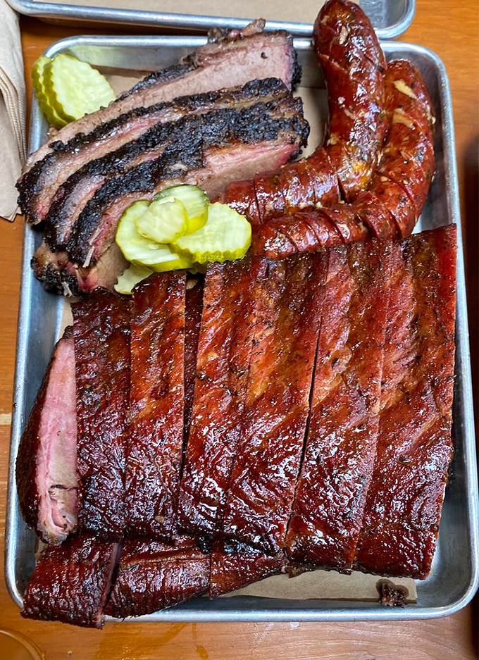 The holy trinity of barbecue: brisket, ribs, and sausage, with sides that aren't afterthoughts. This tray should come with a nap schedule.