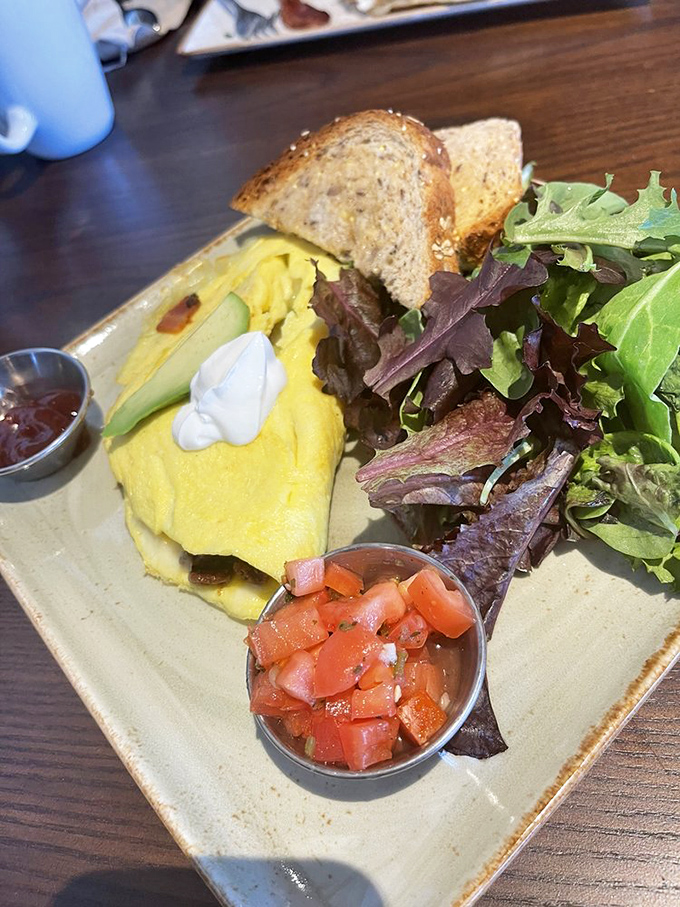This isn't just breakfast&mdash;it's an edible color palette where fluffy eggs meet fresh vegetables and a side salad pretending to balance the equation.