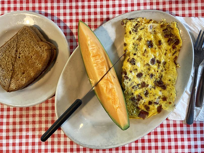 An omelet so fluffy it practically hovers above the plate, paired with home fries that would make any potato proud.