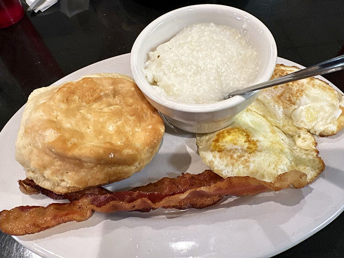 The holy trinity of breakfast: flaky biscuit, crispy bacon, and eggs sunny-side up. Add grits and you've got a Southern benediction.