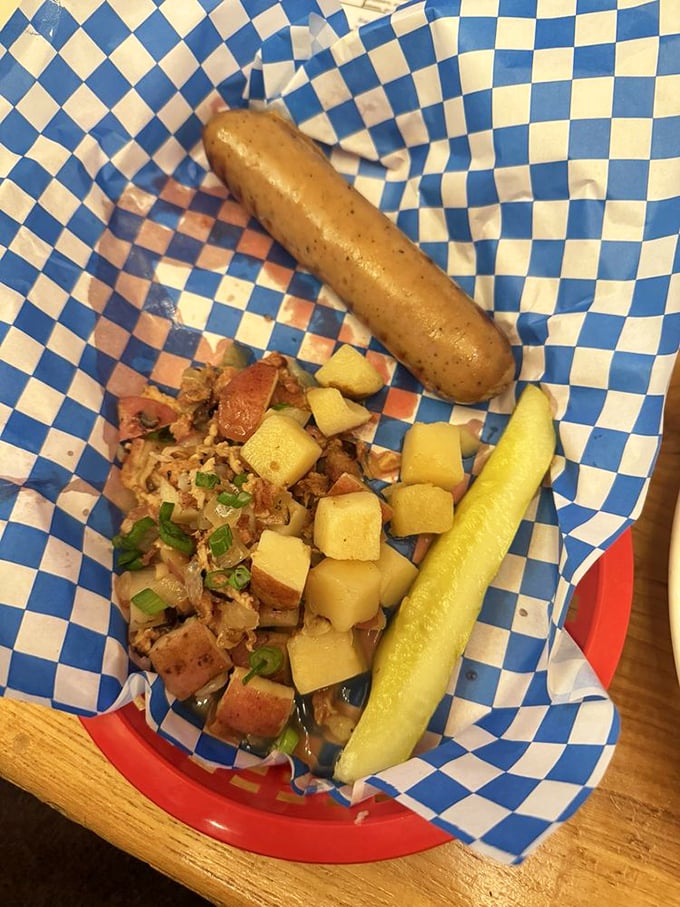 A perfectly grilled bratwurst nestled beside German potato salad and a pickle. This plate is Bavaria's ambassador to the American Midwest. 
