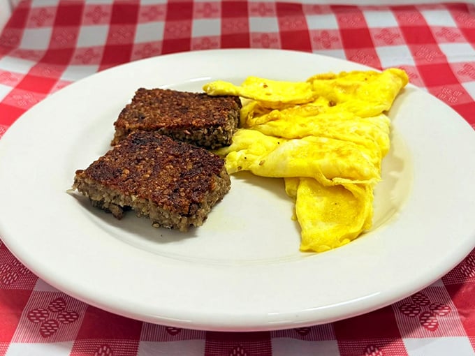 The holy trinity of breakfast perfection: country fried steak smothered in pepper gravy, sunny-side-up eggs, and home fries that could make a potato proud.