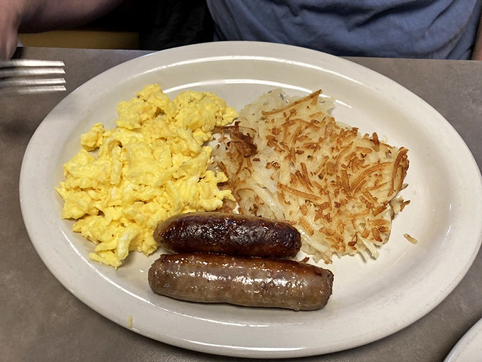 The breakfast holy trinity: perfectly scrambled eggs, sausage links with that satisfying snap, and hash browns crisped to golden perfection.