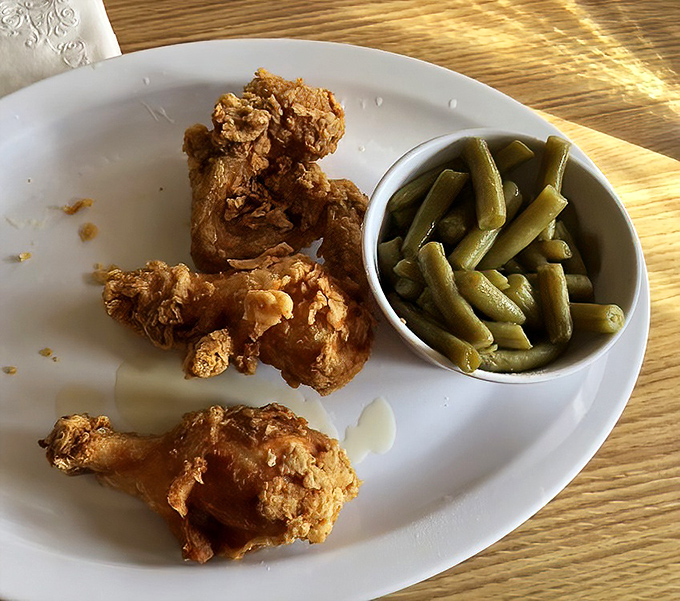 These crispy fried chicken pieces nestled next to perfectly cooked green beans represent the beautiful balance of indulgence and tradition that defines soul food.