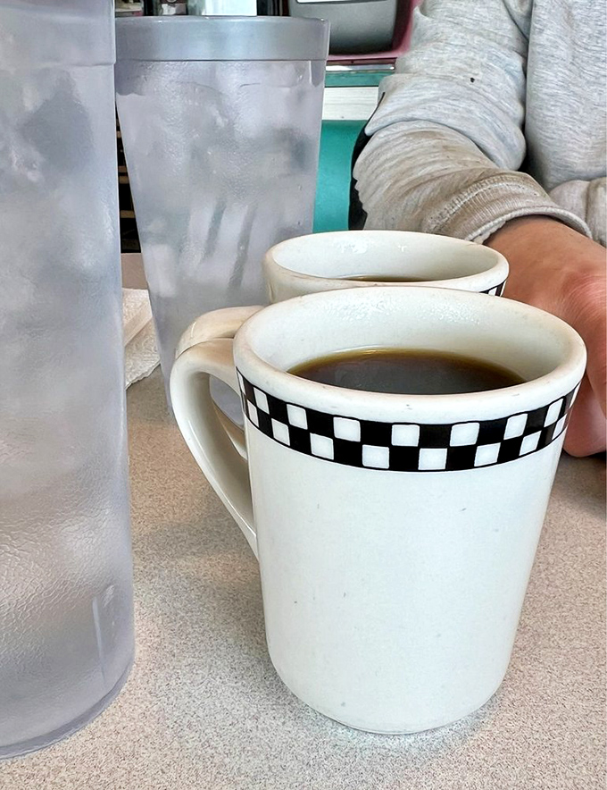 The checkered coffee mug isn't just serving caffeine&mdash;it's serving memories. In diners like this, refills come with a side of conversation.