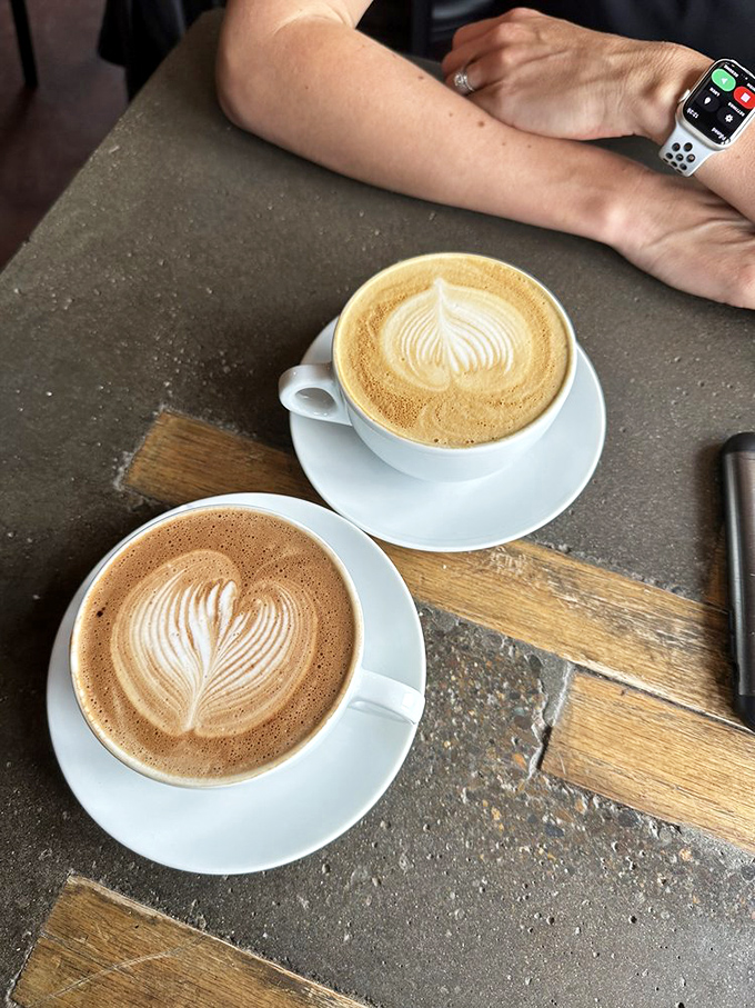 Two lattes, two hearts, one table&mdash;either a romantic coffee date or someone with a serious caffeine dependency. Either way, I approve.