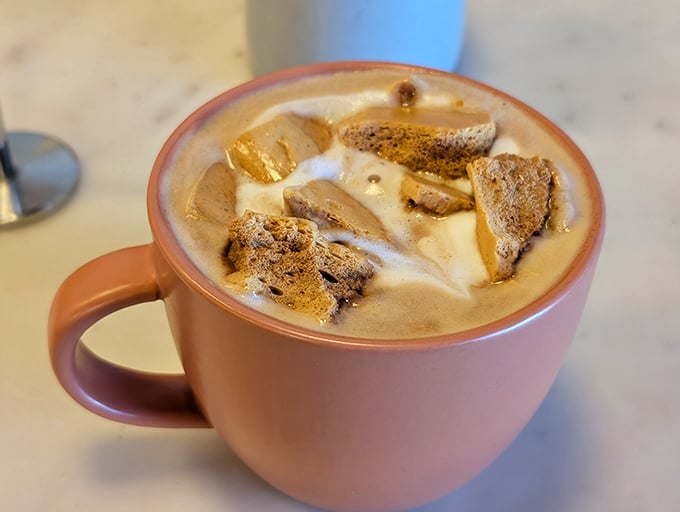 This isn't just coffee, it's a pink mug of comfort&mdash;dalgona foam floating atop steamed milk like delicious, caffeinated clouds.