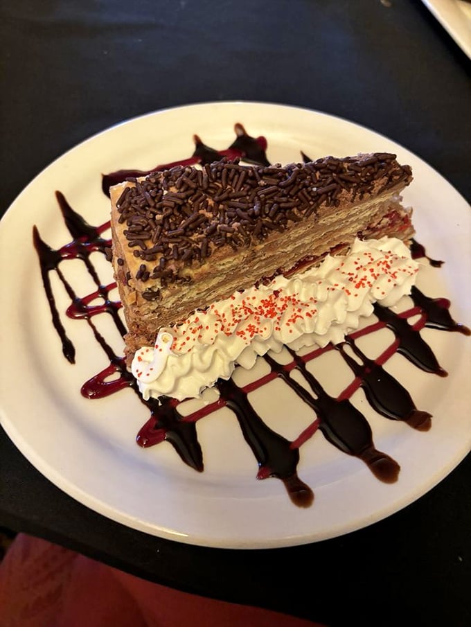 Dessert that demands a moment of silence. Chocolate layered cake with whipped cream and artistic sauce drizzles&mdash;calories that are absolutely worth the splurge.