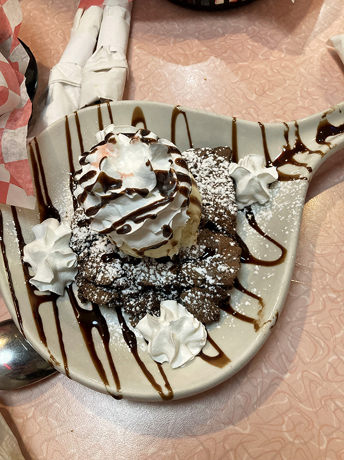 Chocolate drizzle creates edible art on this decadent dessert. With whipped cream dollops standing guard, it's practically begging for your fork's attention.