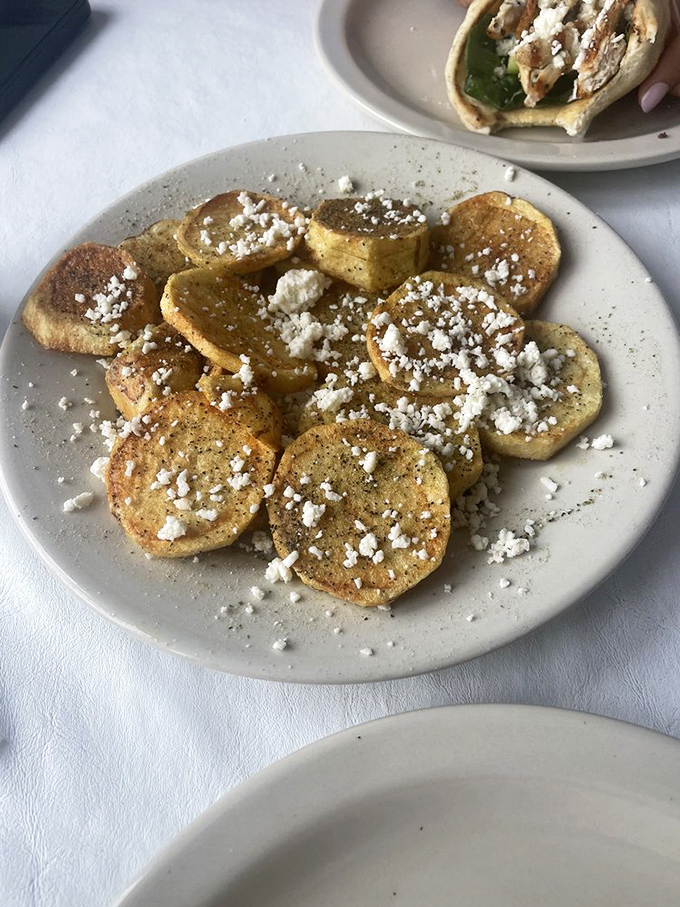 These aren't just potatoes&mdash;they're Greek fries, kissed with herbs and crowned with feta that melts slightly into each golden round.