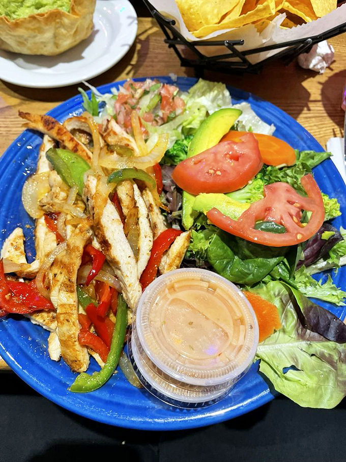 Fresh ingredients having a flavor party on a vibrant blue plate&mdash;this fajita dish is what happens when vegetables and protein decide to tango.