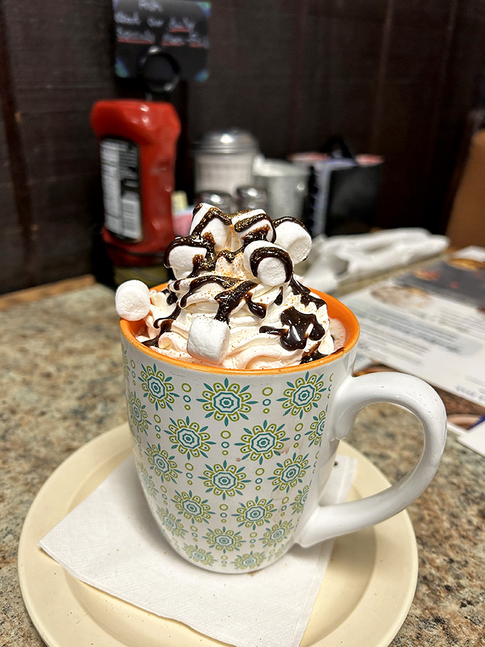Hot chocolate elevated to an art form&mdash;topped with a mountain of whipped cream, marshmallows, and chocolate drizzle. Childhood joy in adult-sized portions.