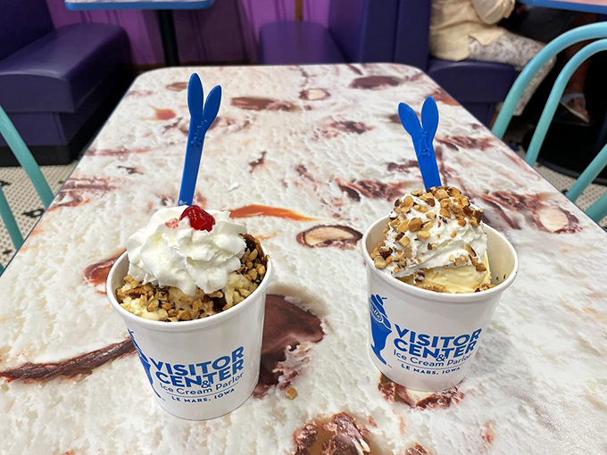 Twin sundaes waiting for their moment of glory. The branded cups aren't just containers—they're small vessels of joy with those signature blue spoons standing ready.
