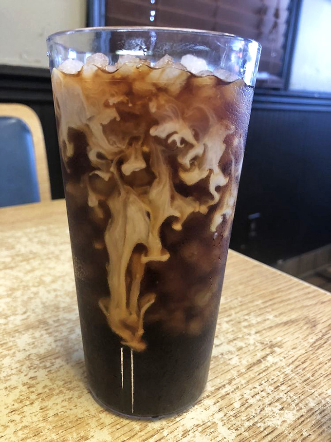 Coffee that performs a slow, mesmerizing dance as cream swirls through dark liquid. Morning meditation in a glass that promises to jumpstart your Charleston adventures.