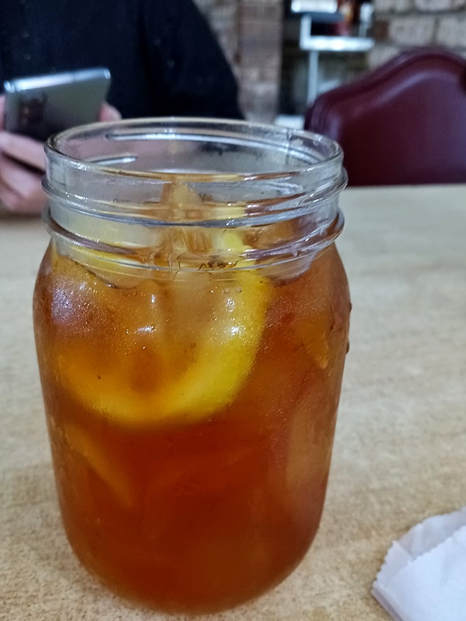 Sweet tea served properly—in a mason jar with enough ice to survive a Southern summer and enough sugar to power you through the day.