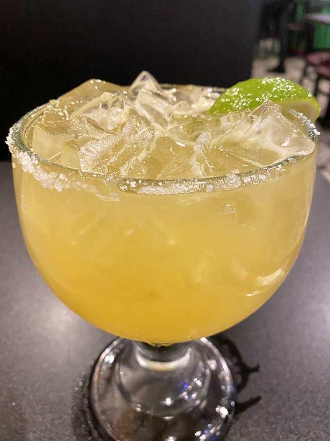 A proper margarita that prioritizes fresh lime over sugar, with a salt rim that extends a proper handshake before the tequila delivers its friendly punch.