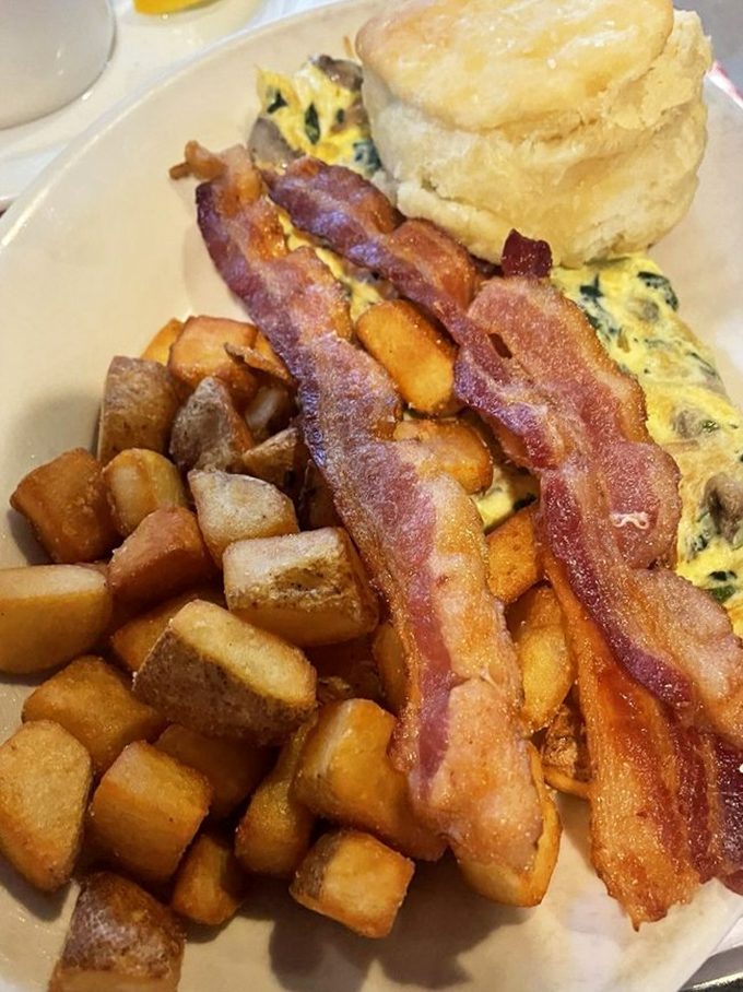 Bacon strips standing at attention next to an omelet and biscuit&mdash;this plate salutes your appetite and waves the white flag at your diet.