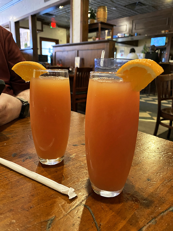 Two glasses of sunshine served with orange slices&mdash;the kind of fresh-squeezed goodness that makes you momentarily forget about your phone.
