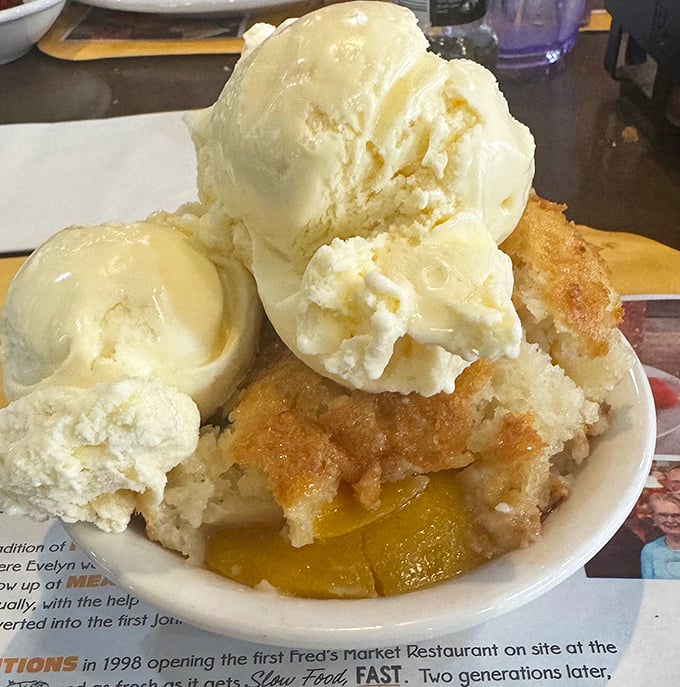 Peach cobbler crowned with vanilla ice cream&mdash;dessert royalty that demands your respect and your spoon. Summer in a bowl.