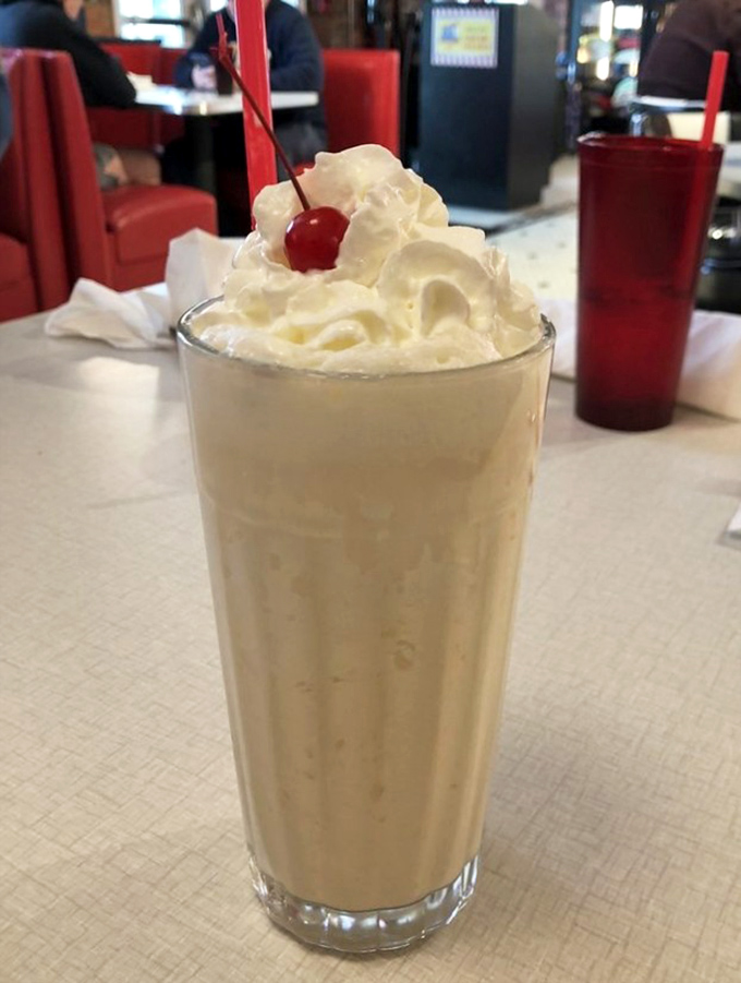 A milkshake crowned with whipped cream and a cherry sentinel. This isn't just dessert&mdash;it's a drinkable monument to happiness.