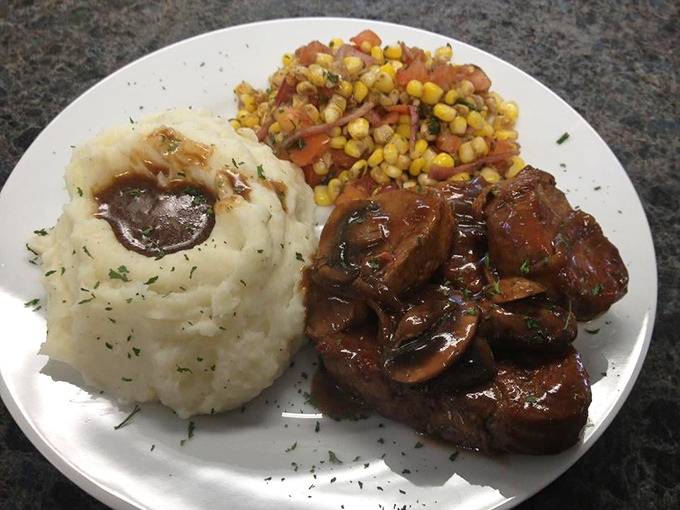 Tender pork tenderloin swimming in rich gravy alongside mashed potatoes and corn&mdash;proof that heaven might actually be a plate in Delaware.