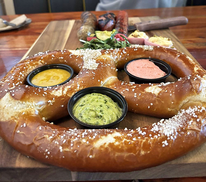 The massive pretzel arrives like an edible sculpture, three dipping sauces nestled in its curves like treasures in a carb-laden treasure chest.