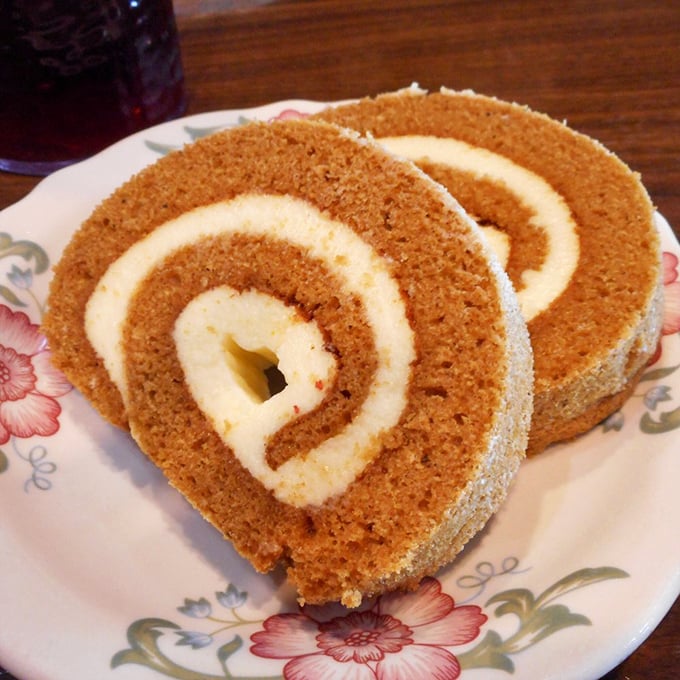 This pumpkin roll isn't just dessert; it's an autumn hug on a floral plate. The cream cheese swirl is performing magic tricks no fancy restaurant can replicate.