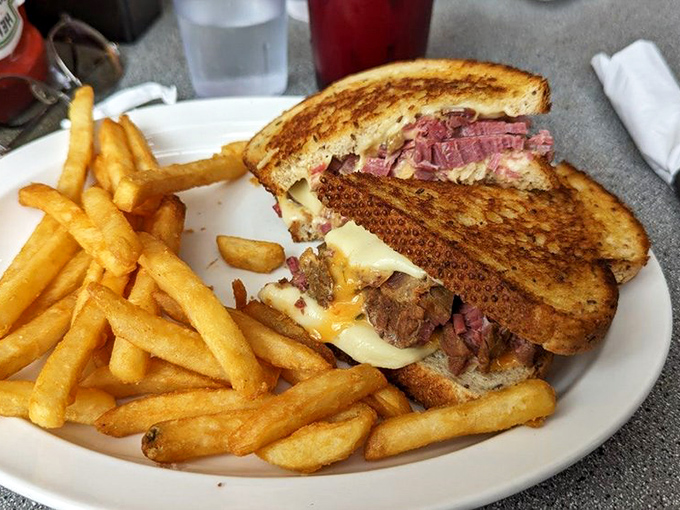 The Reuben sandwich in its natural habitat—surrounded by crispy fries and anticipation. Architecture you can eat.
