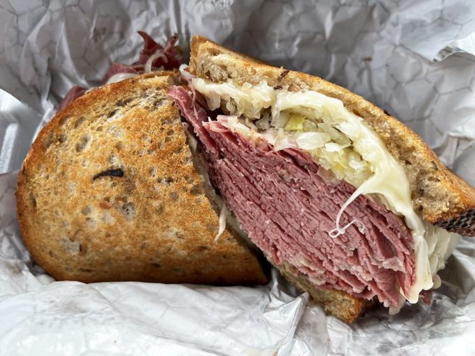 The Reuben in all its glory &ndash; a skyscraper of corned beef, sauerkraut, and melted Swiss that requires both hands and zero shame.