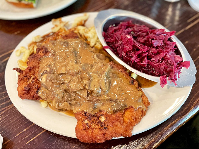 Schnitzel so golden it deserves its own Olympic medal, swimming in mushroom gravy alongside vibrant red cabbage. This plate doesn't just feed you&mdash;it hugs you.